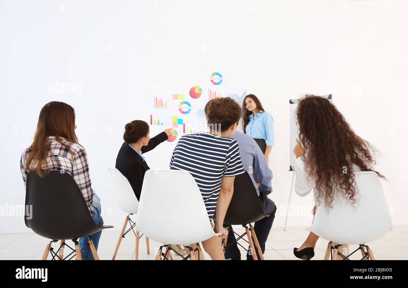 Business trainer giving presentation to group of people Stock Photo - Alamy