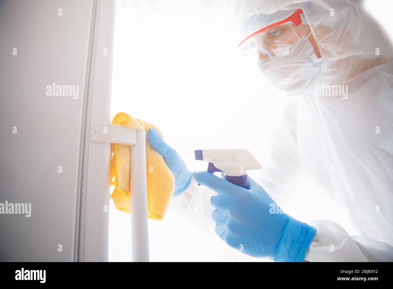 Close-up antiseptic cleaning door handle of refrigerator disinfection ...