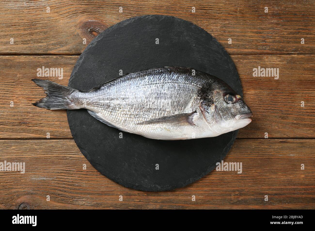 Raw fish on slate plate Stock Photo - Alamy