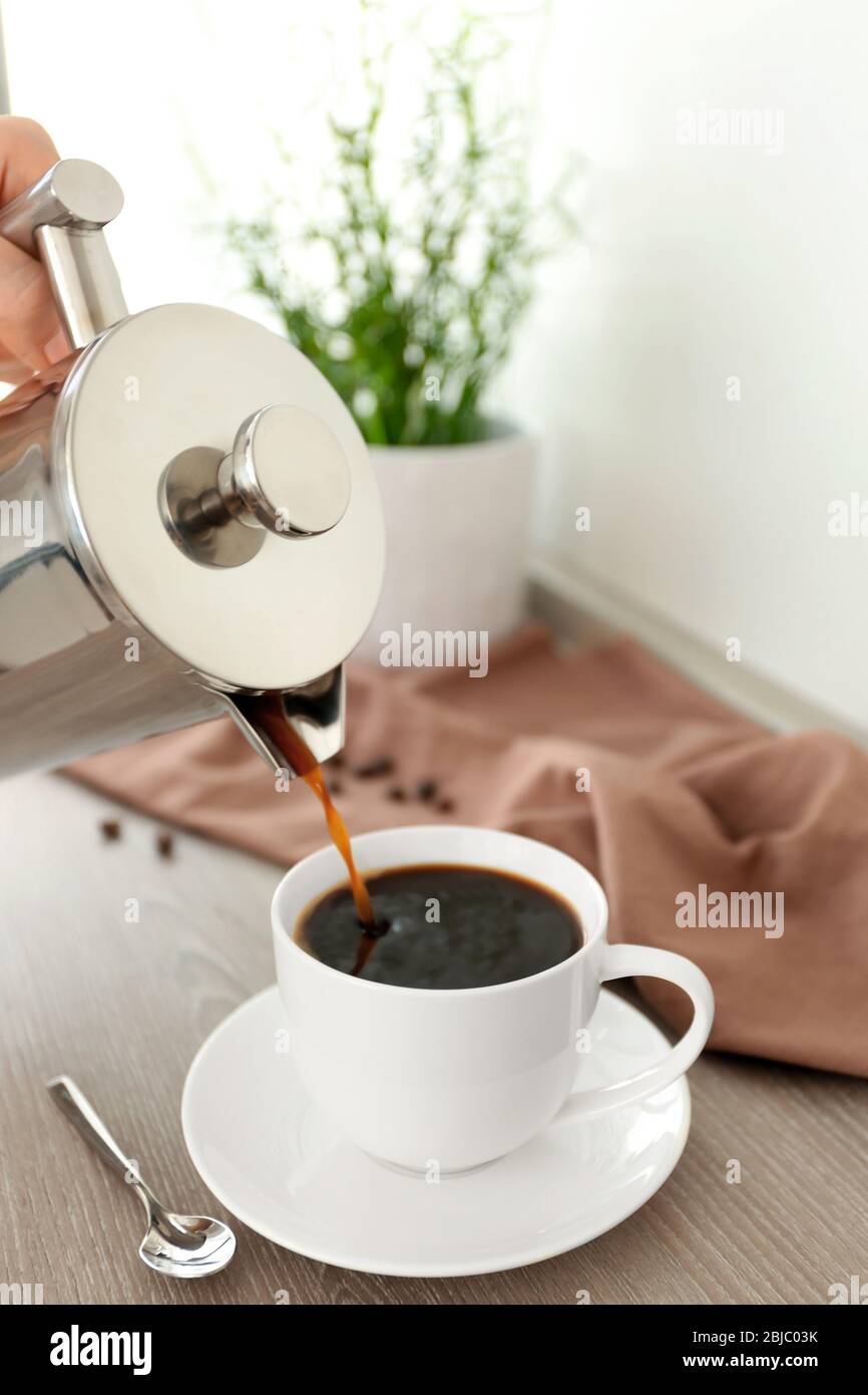 Fresh coffee pouring from pot into cup Stock Photo - Alamy