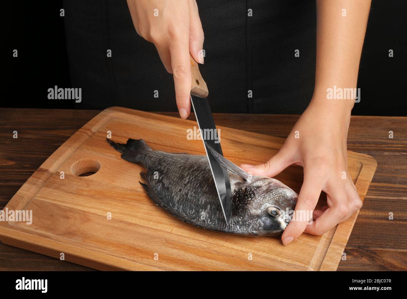 Woman cooking raw fish hi-res stock photography and images - Alamy