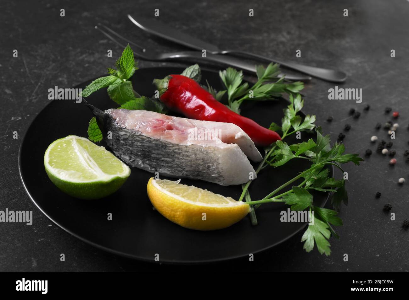 Raw fish slice with spices on plate Stock Photo - Alamy