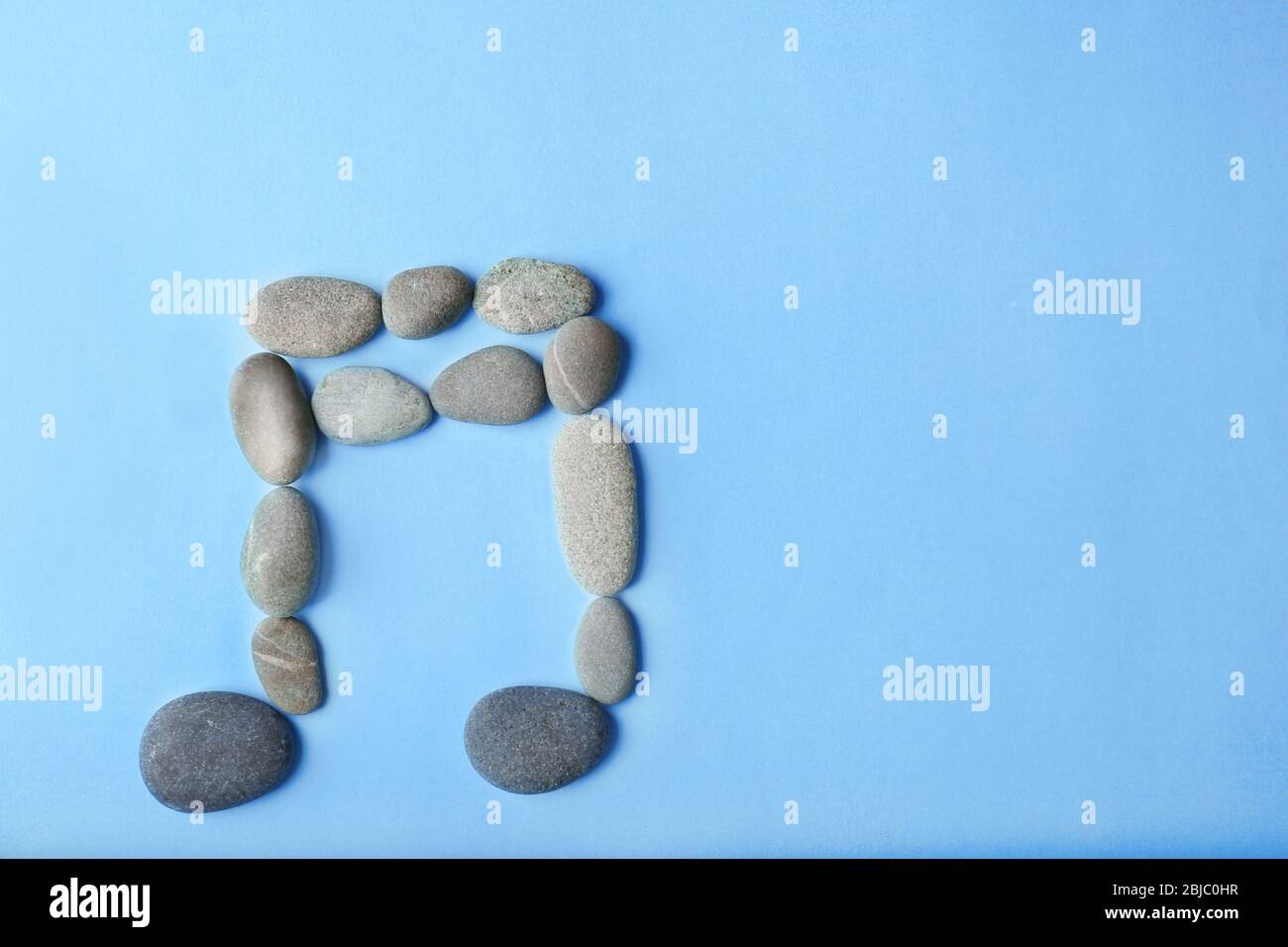 Music note sign made of stones on light blue background Stock Photo - Alamy