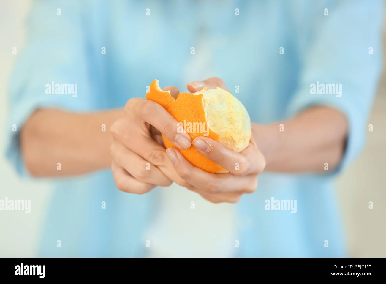 Female hands peeling orange, closeup Stock Photo - Alamy