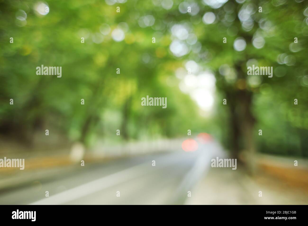 Blurred background of asphalt road leading along autumn park Stock ...