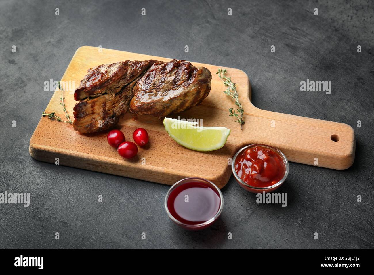 Composition of tasty steak and ingredients on kitchen table Stock Photo ...