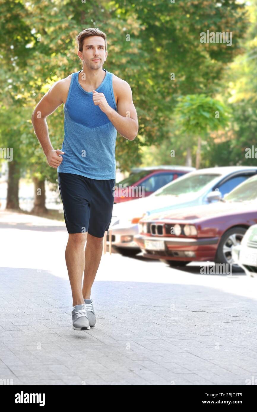 Young sportsman running in the street Stock Photo - Alamy