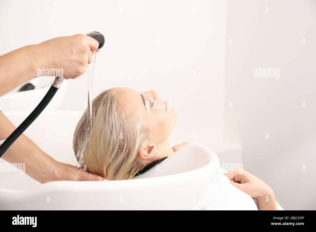 Hairdresser washing young womans hair hi-res stock photography and ...