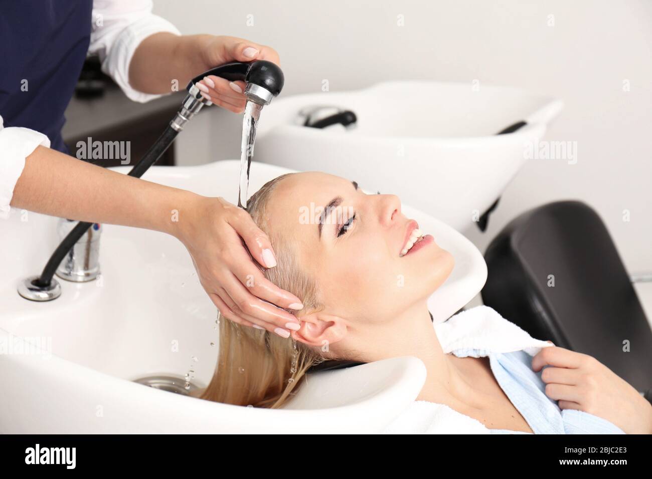 Hairdresser washing woman's hair in salon Stock Photo - Alamy