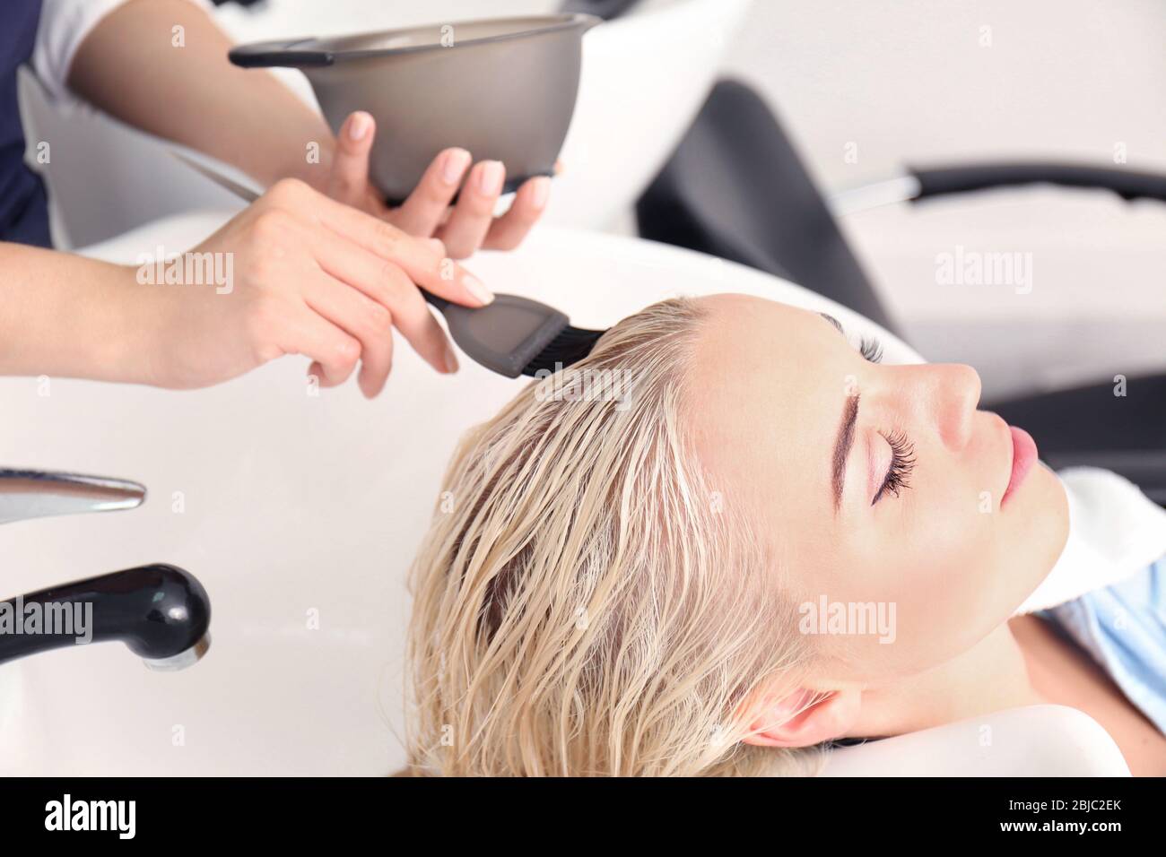Hairdresser putting mask on woman's hair in salon Stock Photo - Alamy