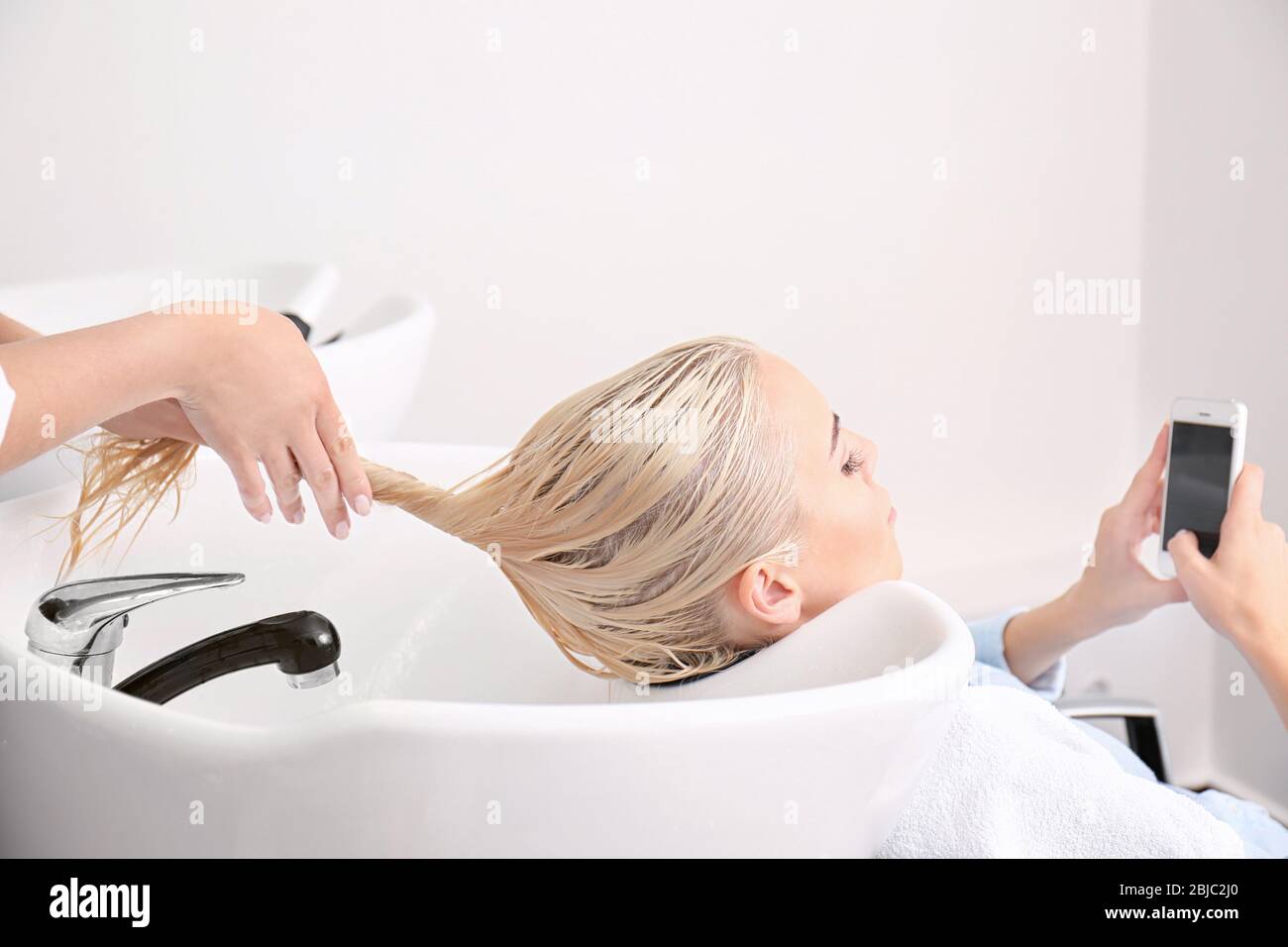 Hairdresser washing young womans hair hi-res stock photography and ...