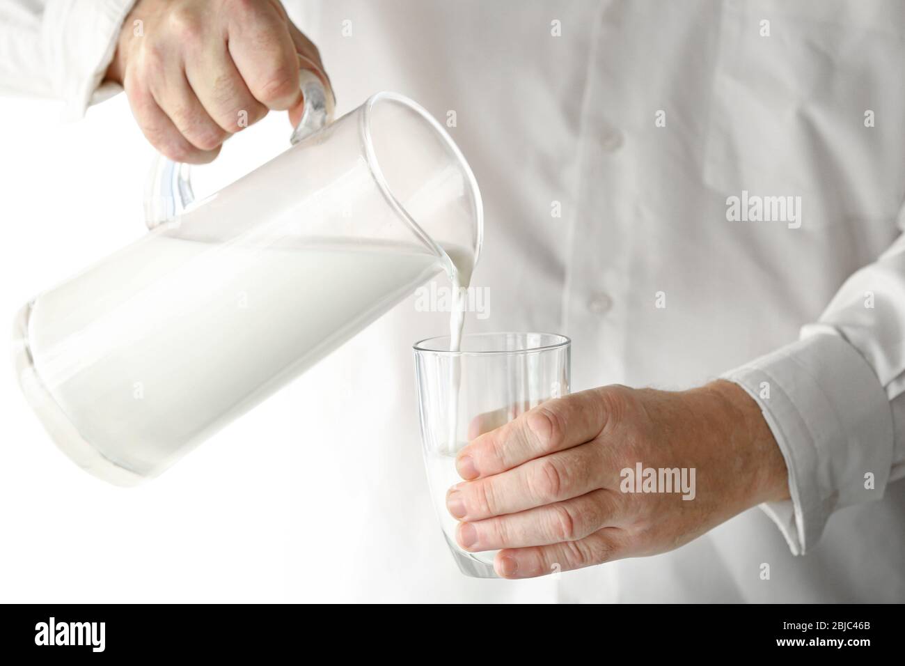 Senior man pouring milk into glass Stock Photo - Alamy