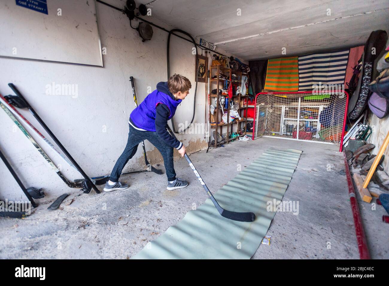 boy training in hockey home garage shooting range during Covid-19 ...
