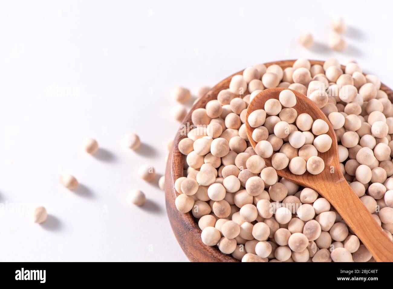 Dry raw brown tapioca pearls in a wooden bowl with spoon isolated on ...