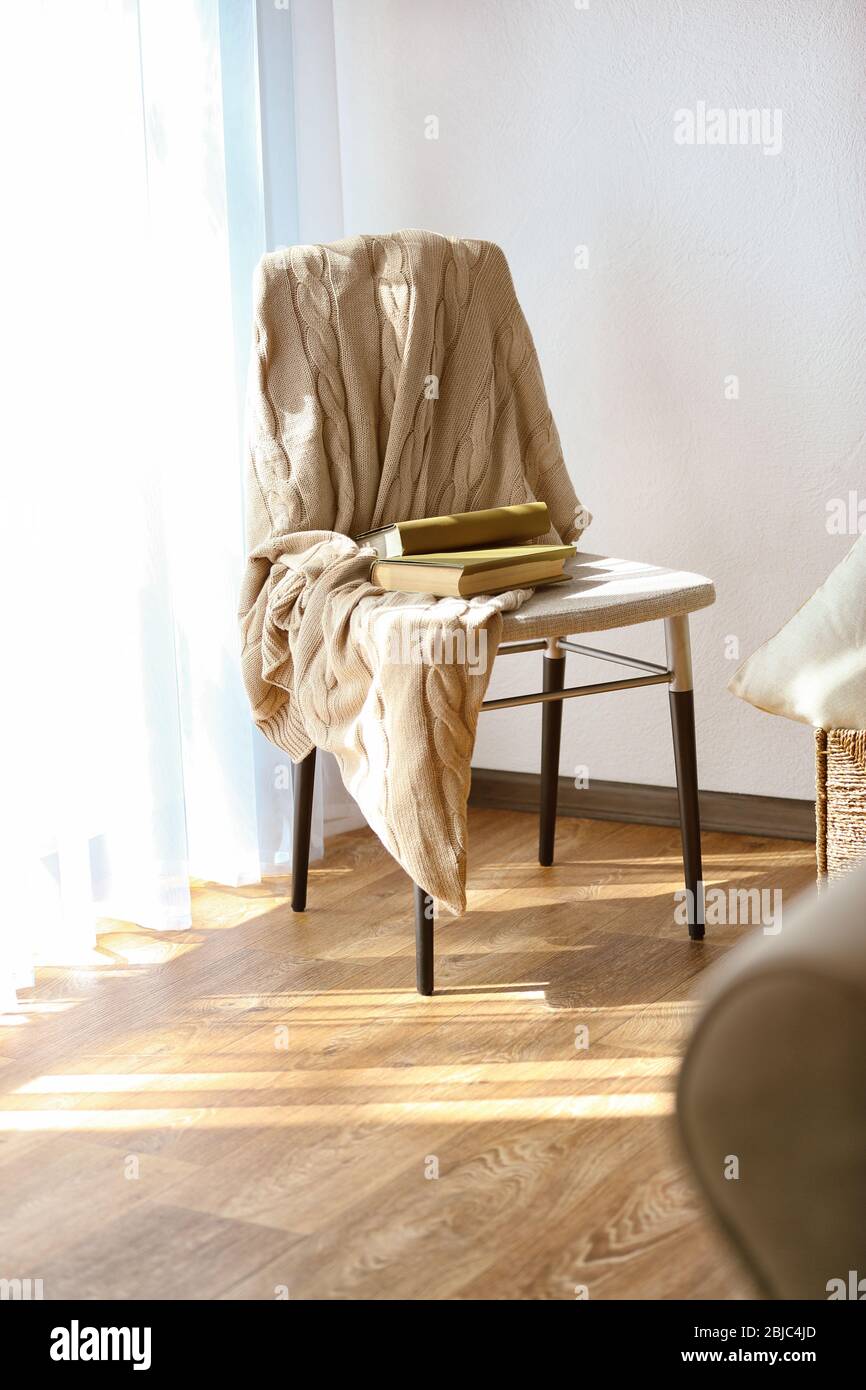 Books with plaid on chair Stock Photo - Alamy