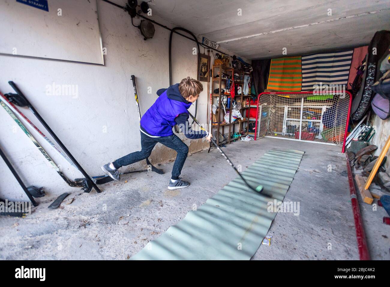 boy training in hockey home garage shooting range during Covid-19 ...