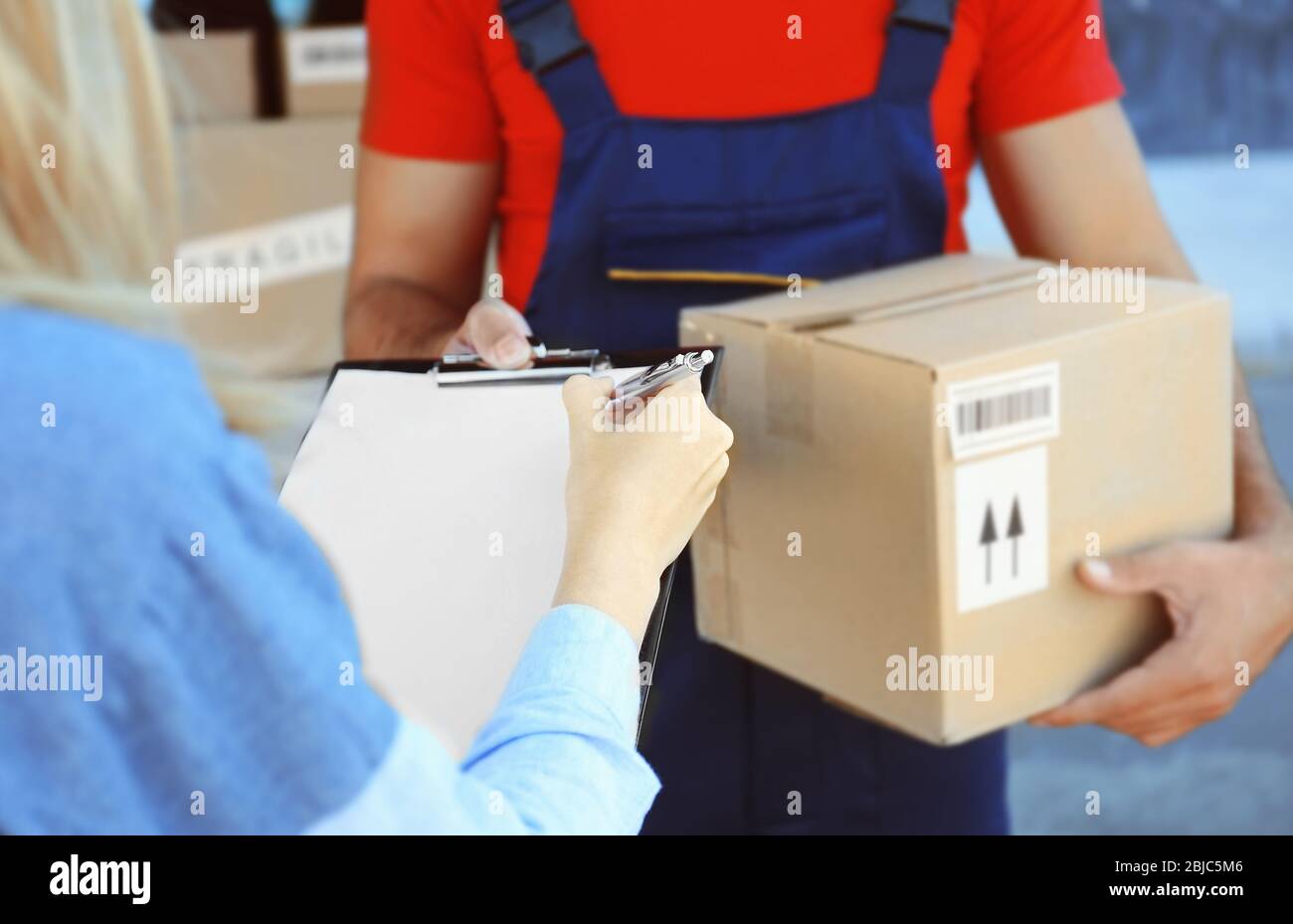 Deliveryman delivering parcel client closeup hi-res stock photography ...