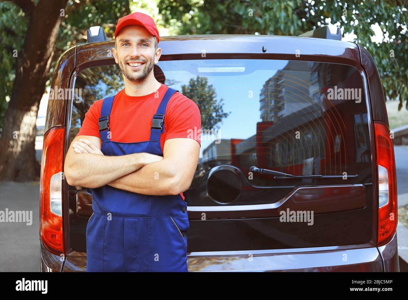 Delivery man standing beside car Stock Photo - Alamy
