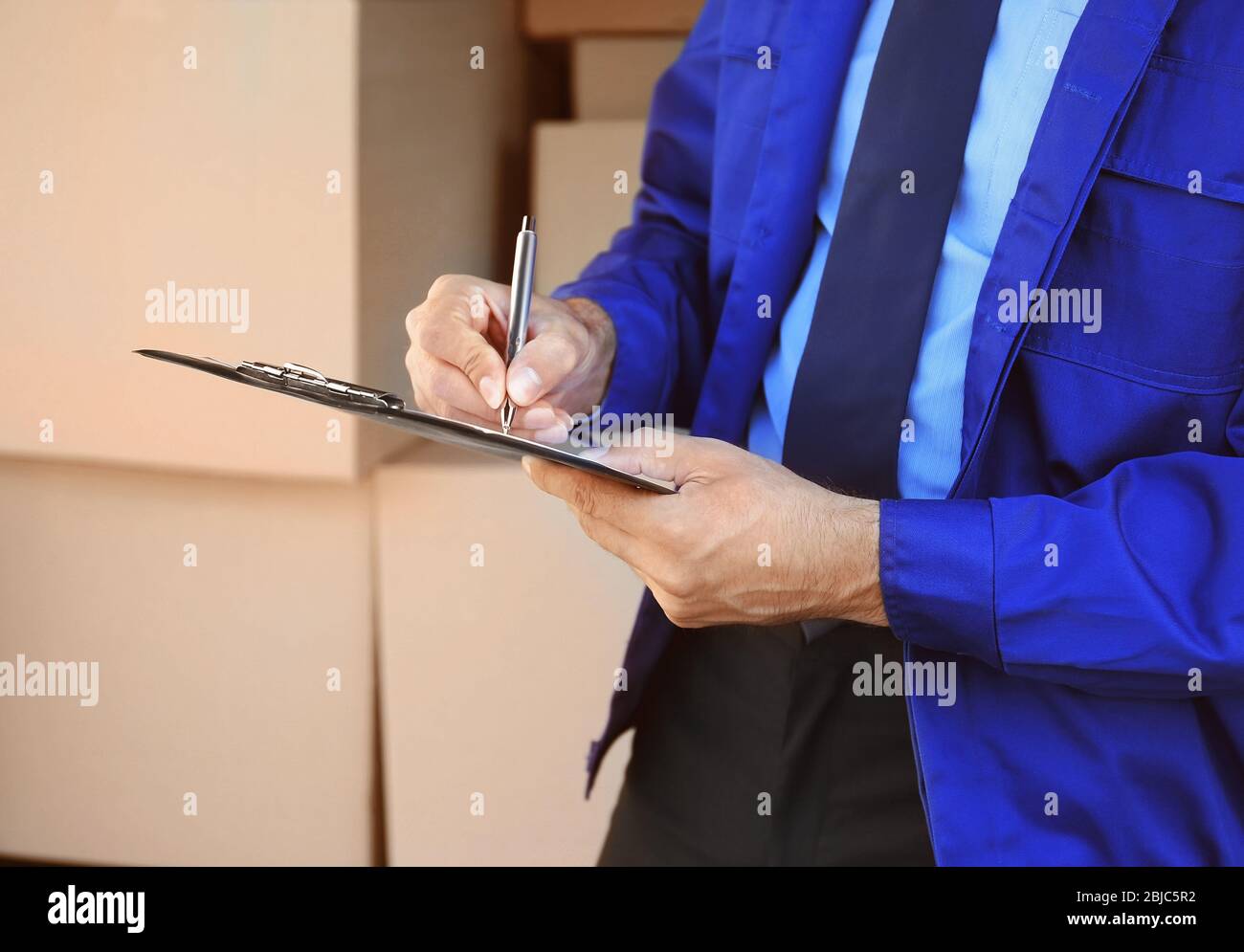 Delivery man checking list on clipboard Stock Photo - Alamy