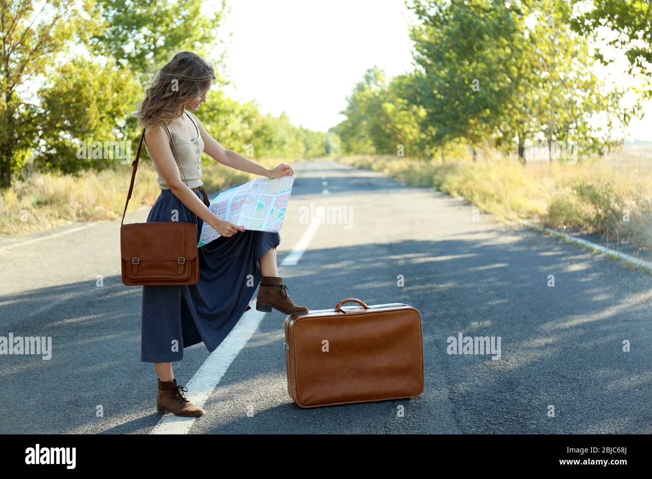Young woman searching direction on map Stock Photo - Alamy