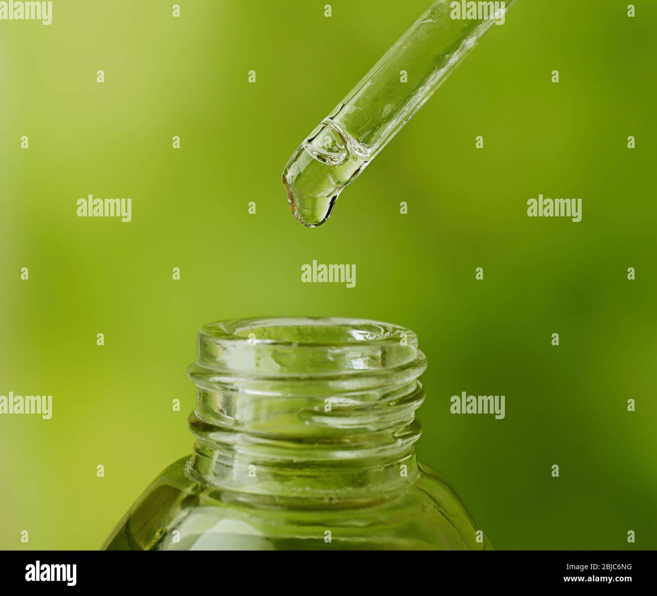 Dropper and essential oil on blurred background Stock Photo - Alamy