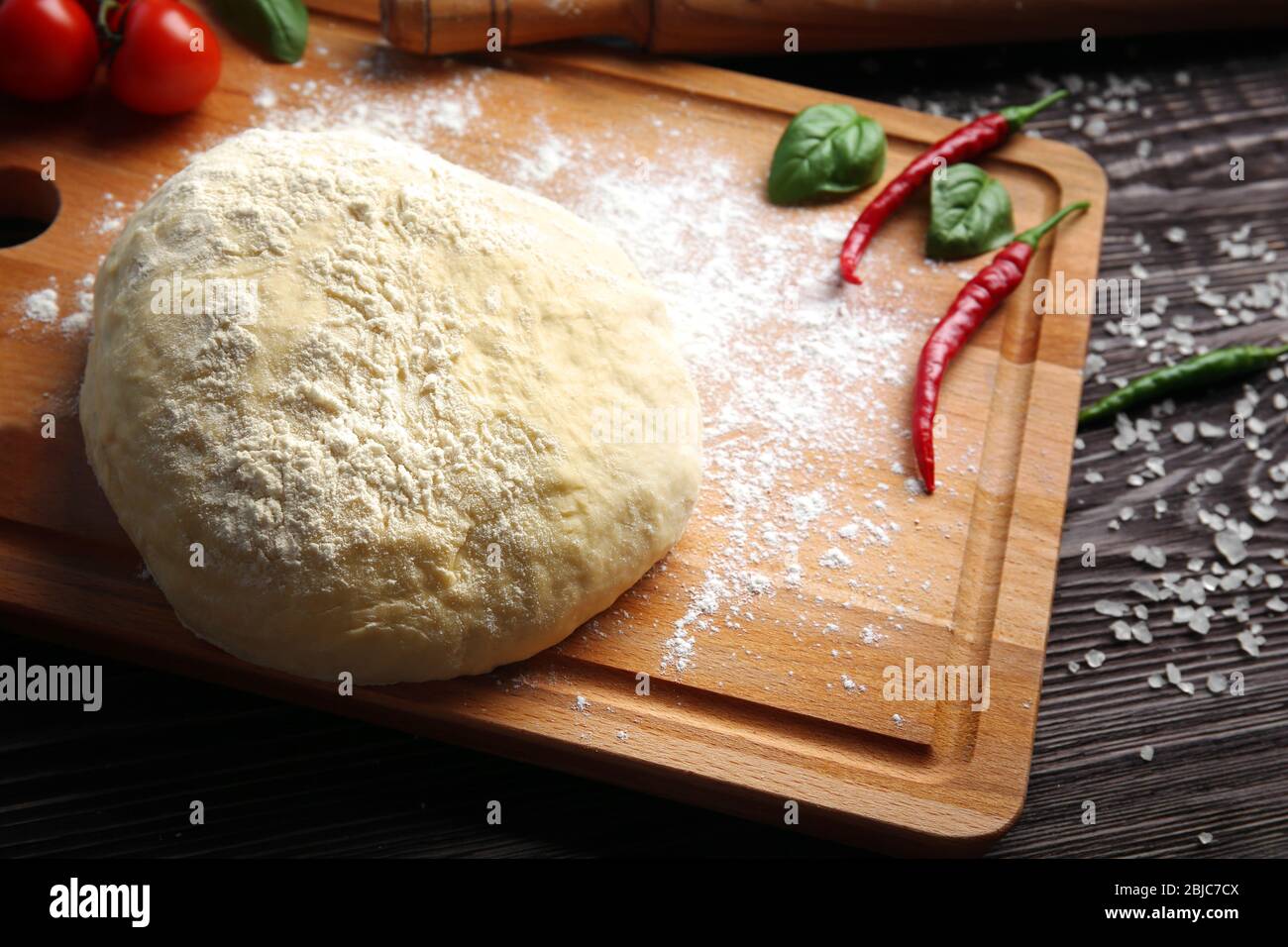Preparation homemade pizza on kitchen table Stock Photo - Alamy