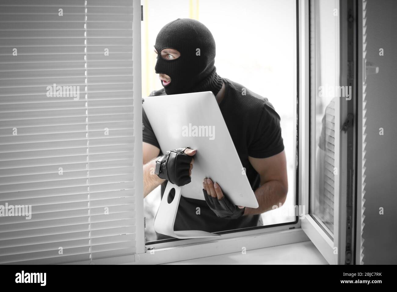 Thief stealing monitor from office Stock Photo - Alamy