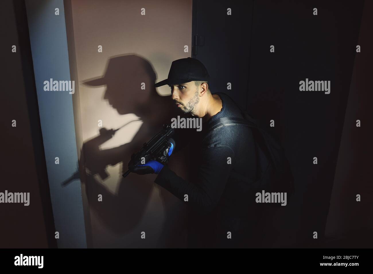 Male thief with gun in house Stock Photo - Alamy