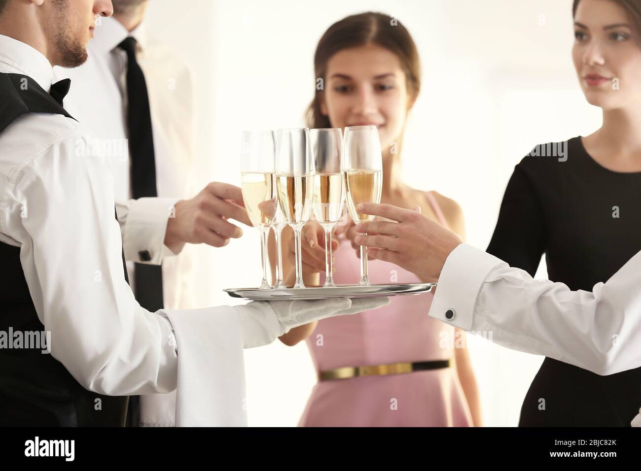 Waiter in uniform serving champagne during buffet catering party Stock ...