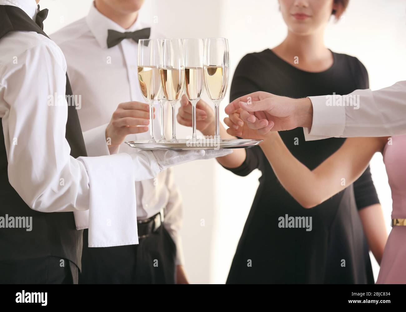Waiter in uniform serving champagne during buffet catering party Stock ...