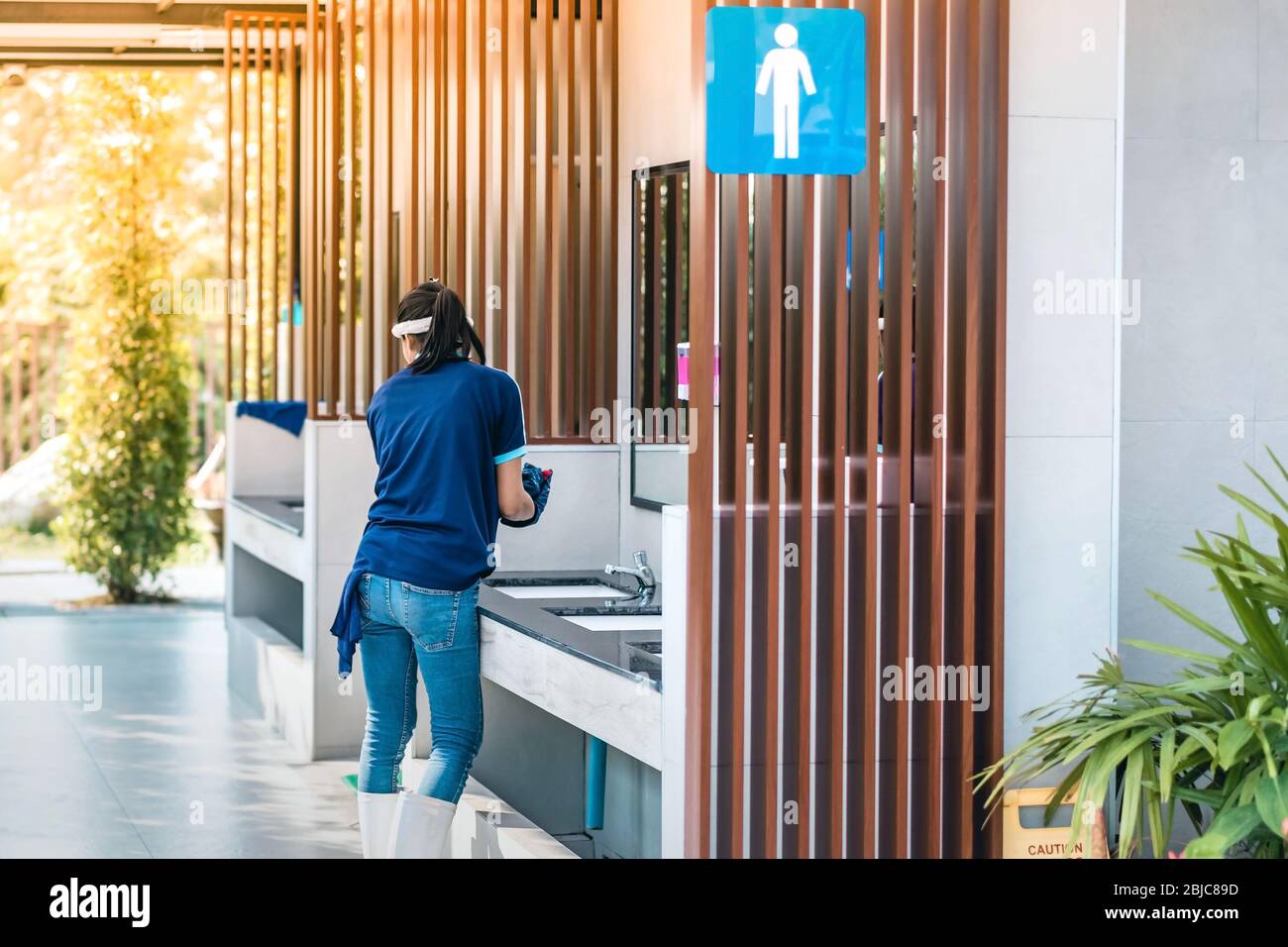 Female janitor using fabric and a detergent cleaning sink and tap in ...