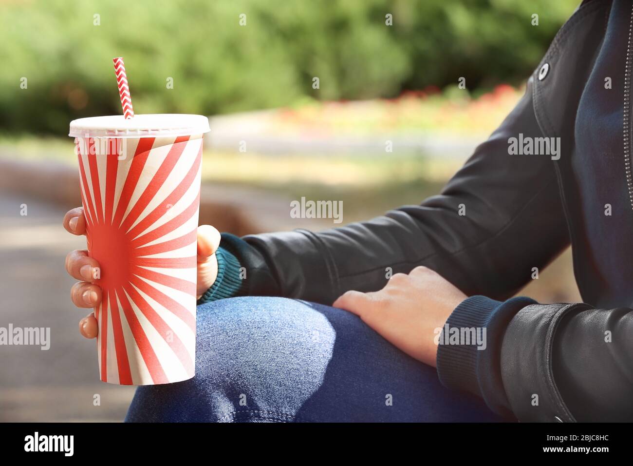 Female hand holding cup with drink on street Stock Photo - Alamy