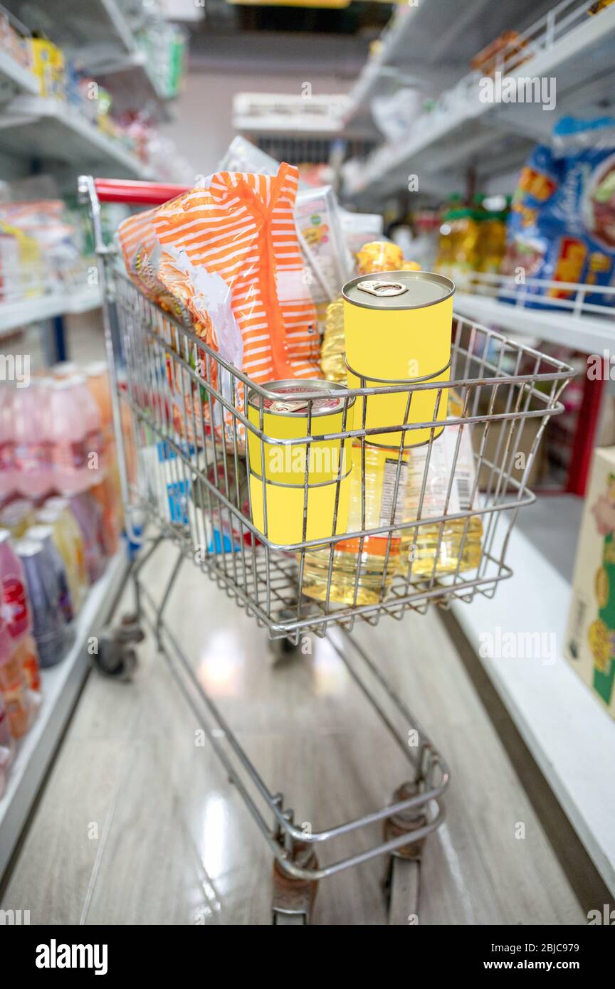 Shopping cart with hoarding product of food in aisle at grocery store ...