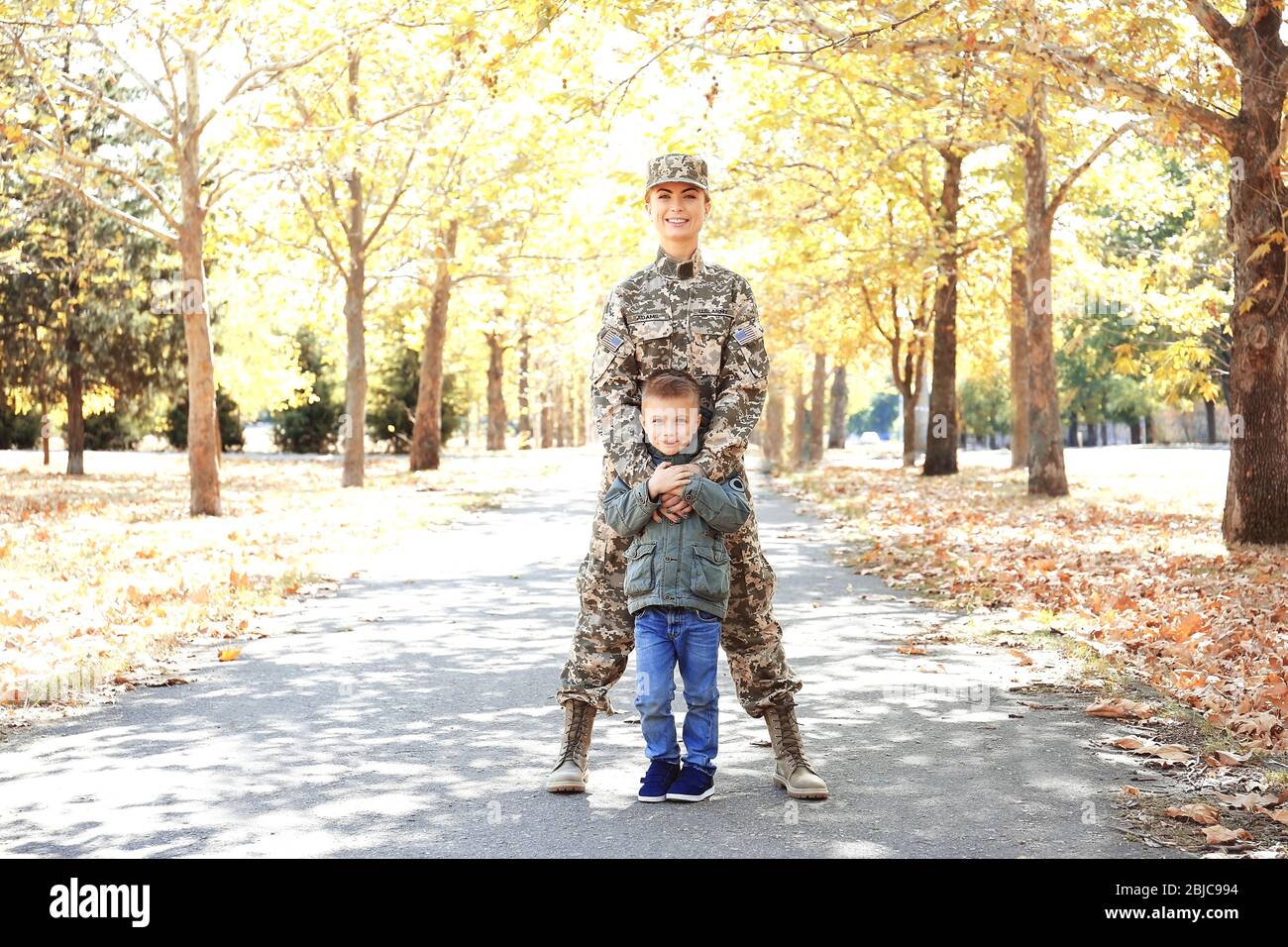 Mother soldier and little kid embracing in the park Stock Photo - Alamy