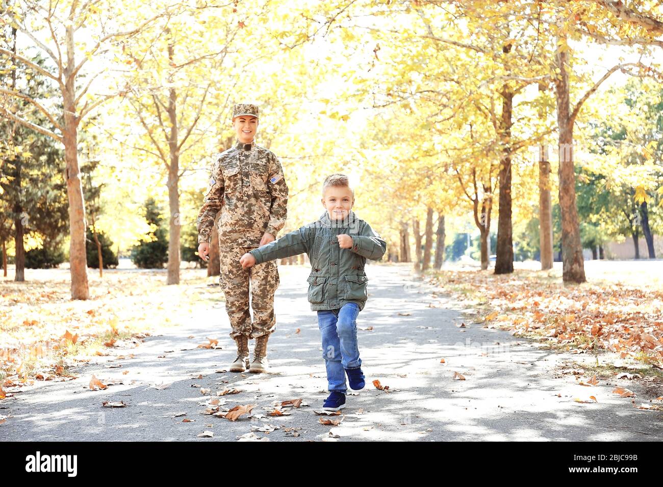 Mother soldier and little kid walking in the park Stock Photo - Alamy