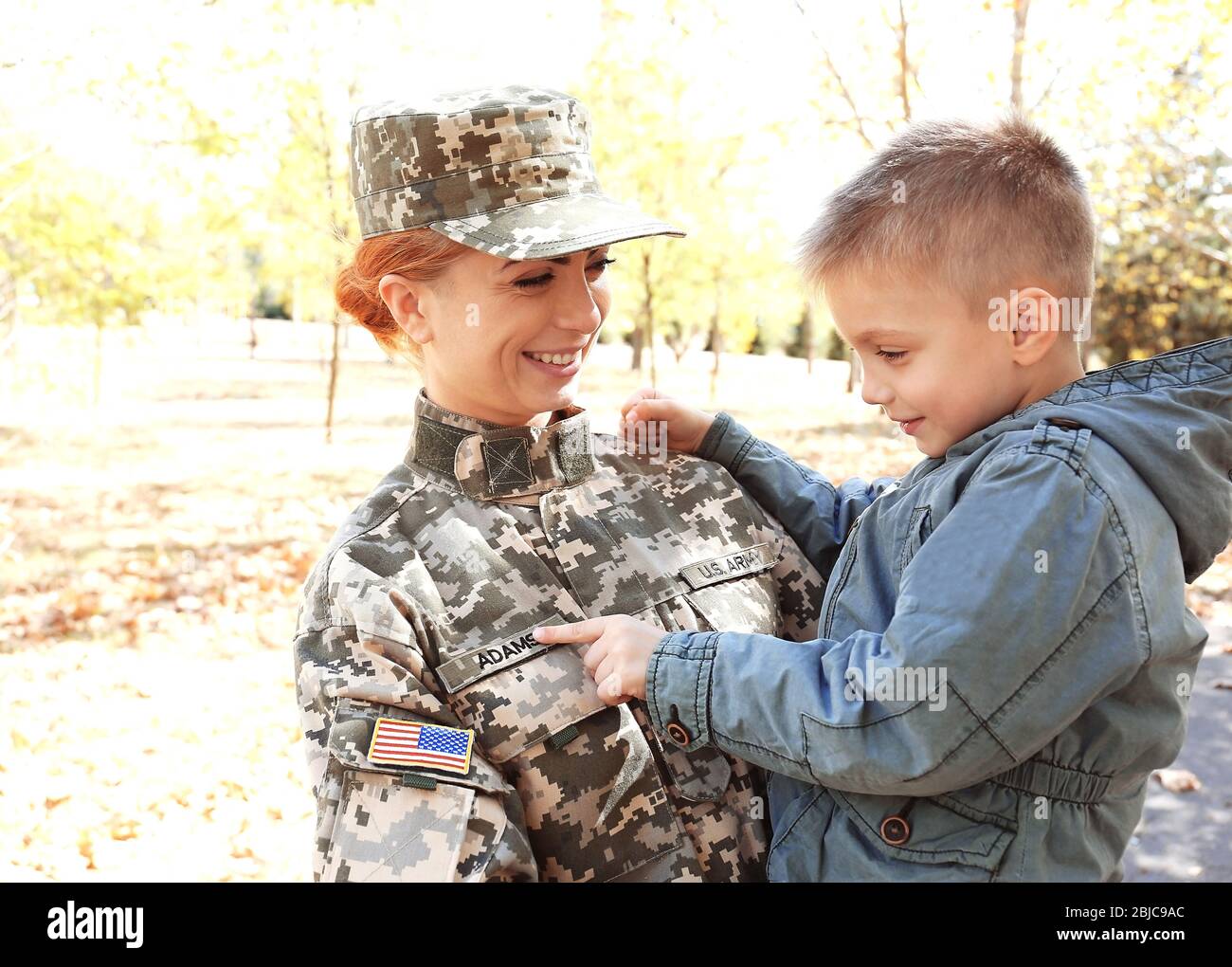 Mother soldier and little kid embracing in the park Stock Photo - Alamy