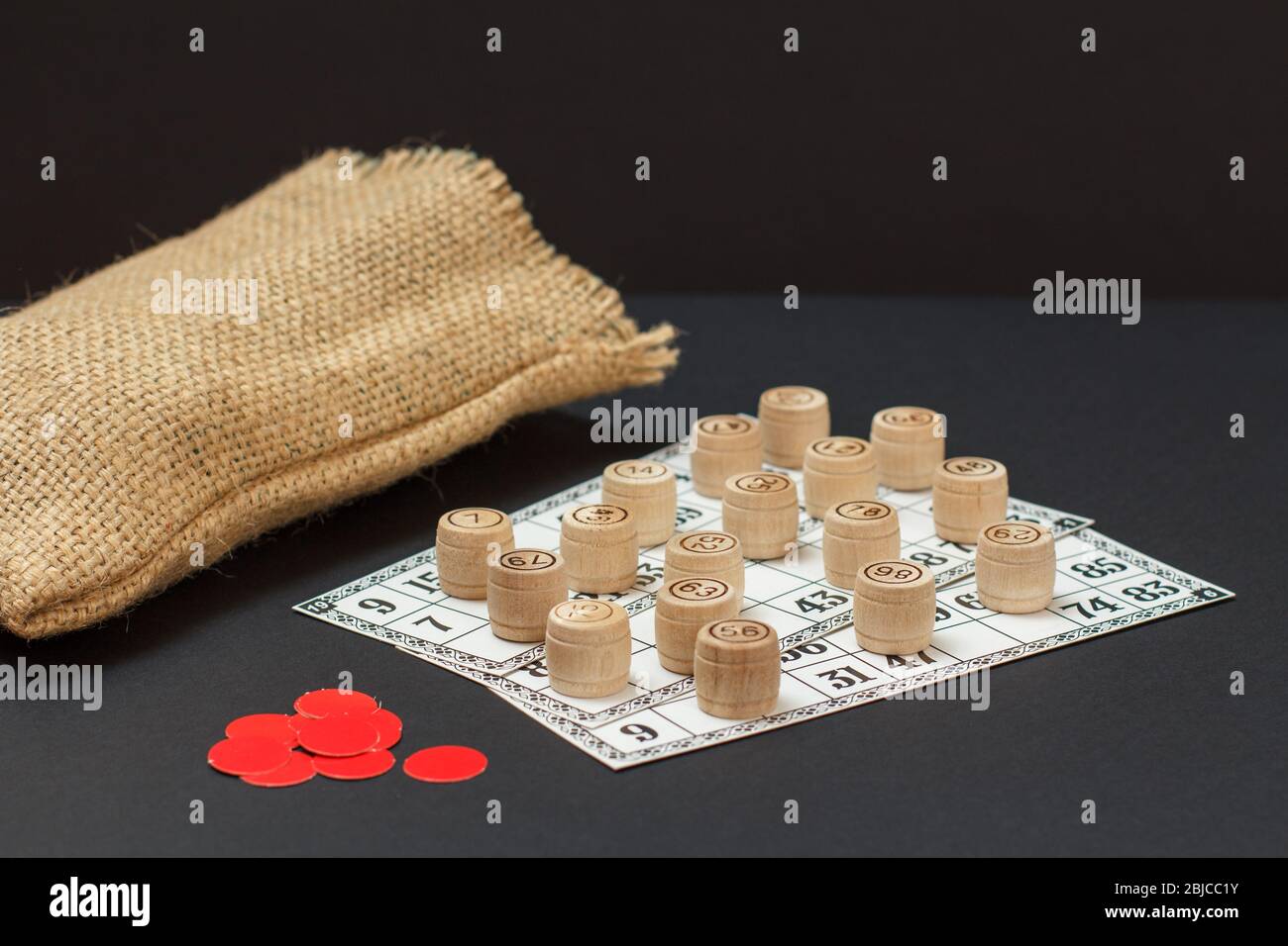 Board game lotto. Wooden lotto barrels with a bag, game cards and red ...