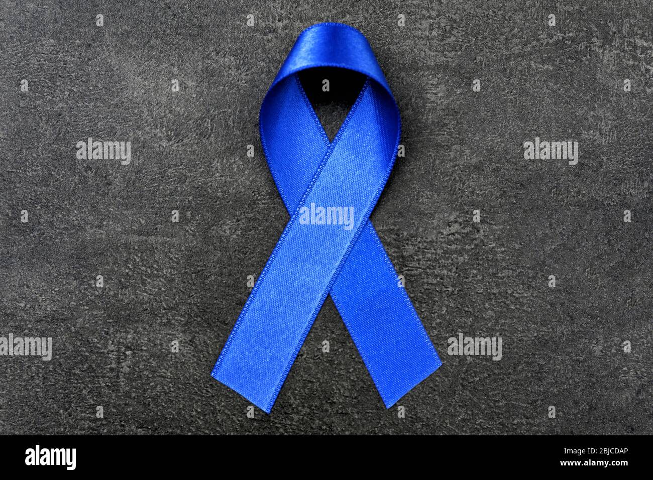 Blue ribbon on dark background. Colon cancer concept Stock Photo - Alamy