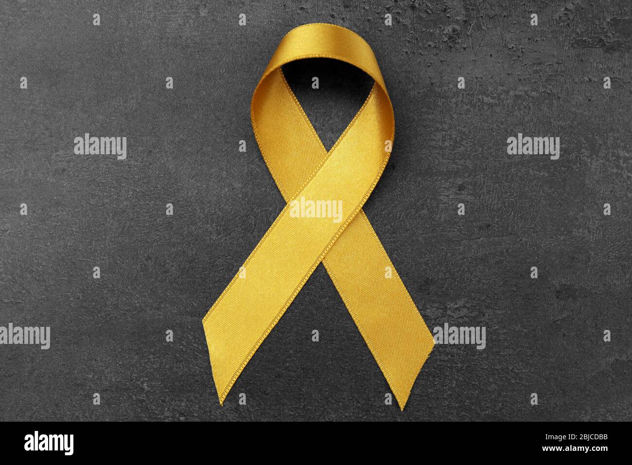 Golden ribbon on dark background. Children cancer concept Stock Photo ...