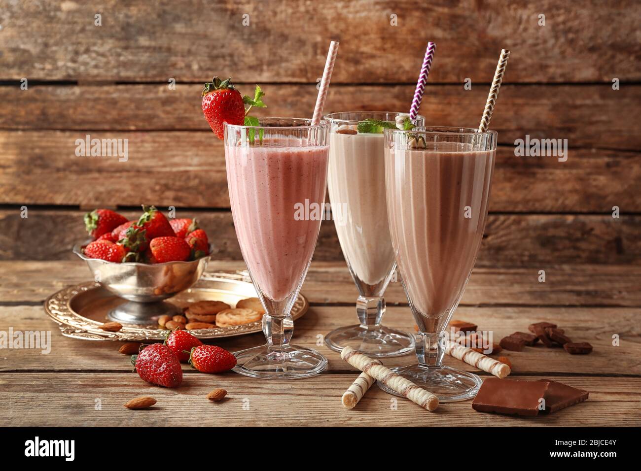 Delicious milkshakes on wooden background Stock Photo - Alamy