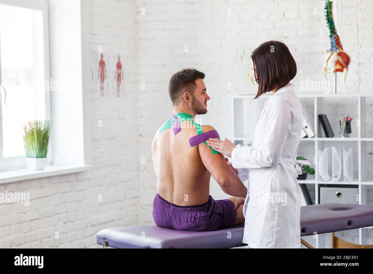 Kinesiology taping. Physical therapist applying kinesiology tape to patient neck. Therapist ...