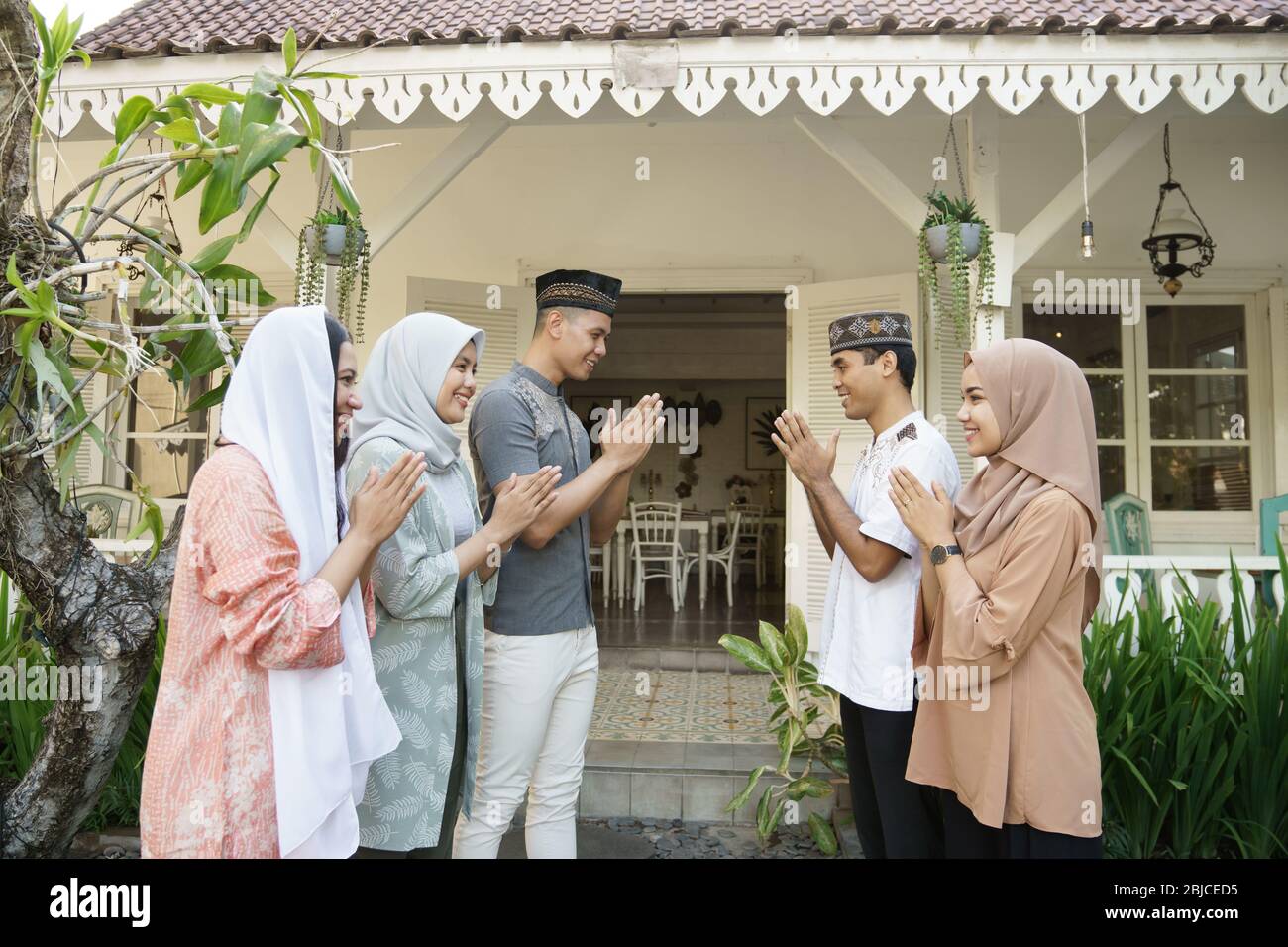 muslim family welcoming friend at home. visiting during eid mubarak ...