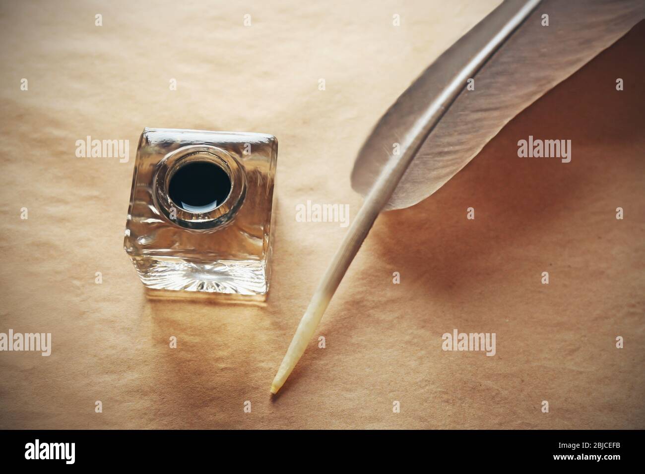 Feather pen and inkwell on paper background Stock Photo - Alamy