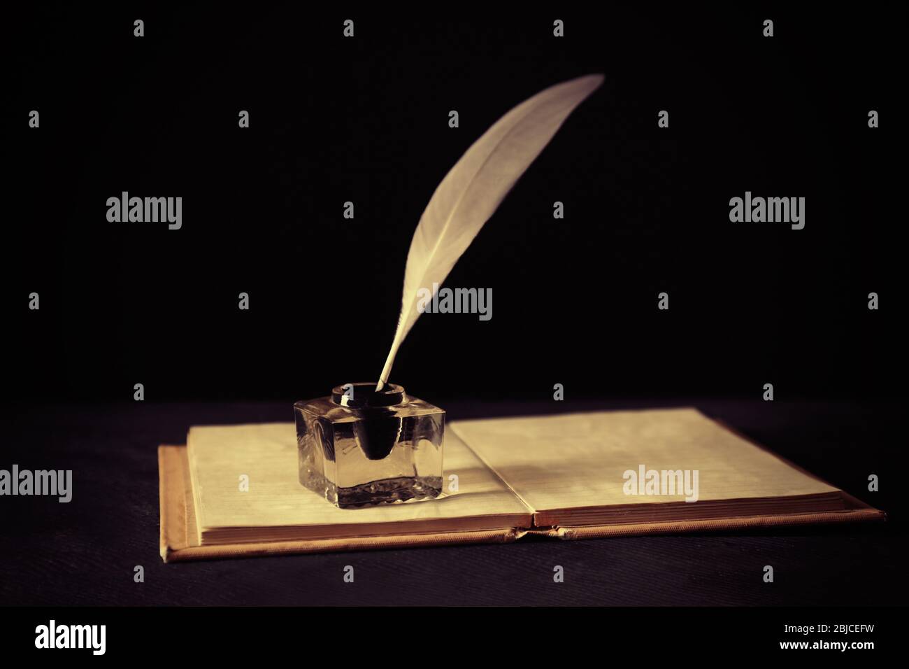 Feather pen with inkwell and open notebook on dark background Stock ...