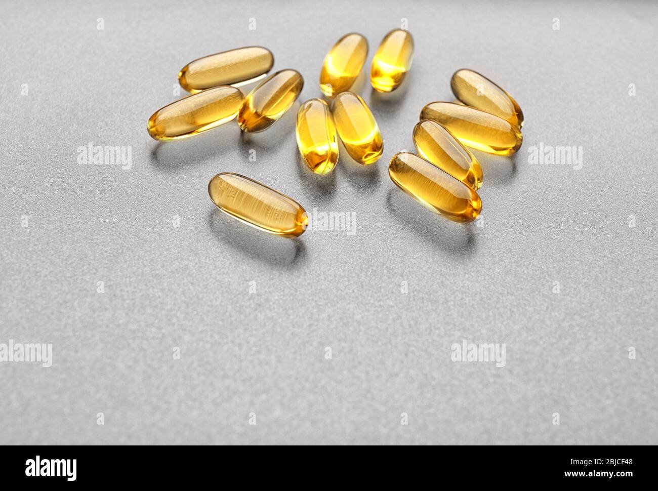 Fish oil capsules on grey background Stock Photo - Alamy