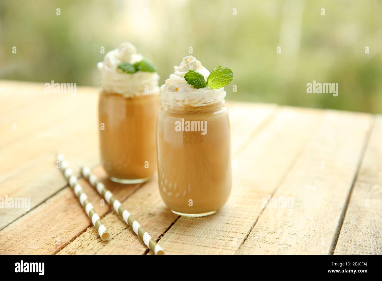 Tasty milk shake cocktails on wooden table Stock Photo - Alamy