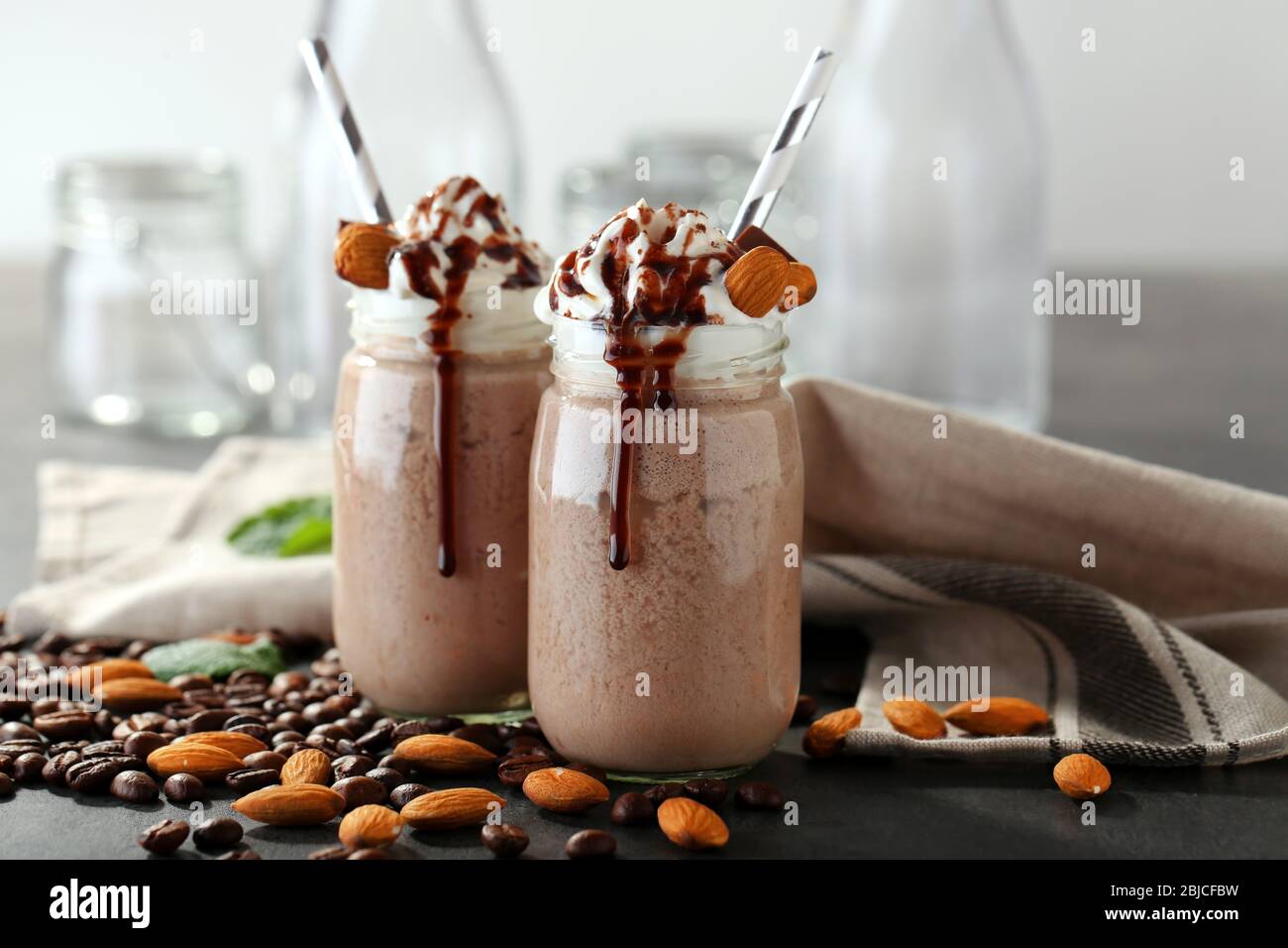 Tasty milk shake cocktails with coffee beans and almond nuts on table ...