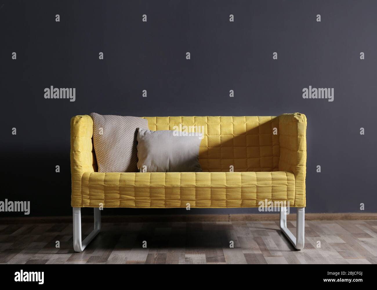 Modern couch on dark wall background Stock Photo - Alamy