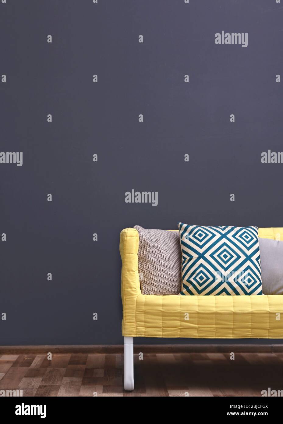 Modern couch on dark wall background Stock Photo - Alamy