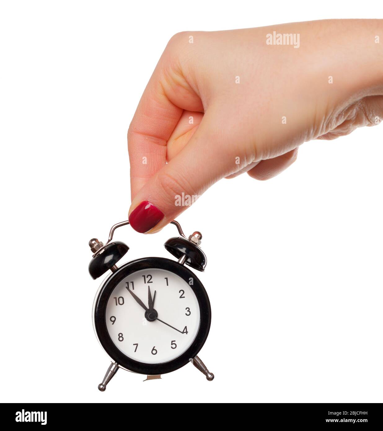 Female hand holding alarm clock on white background Stock Photo - Alamy